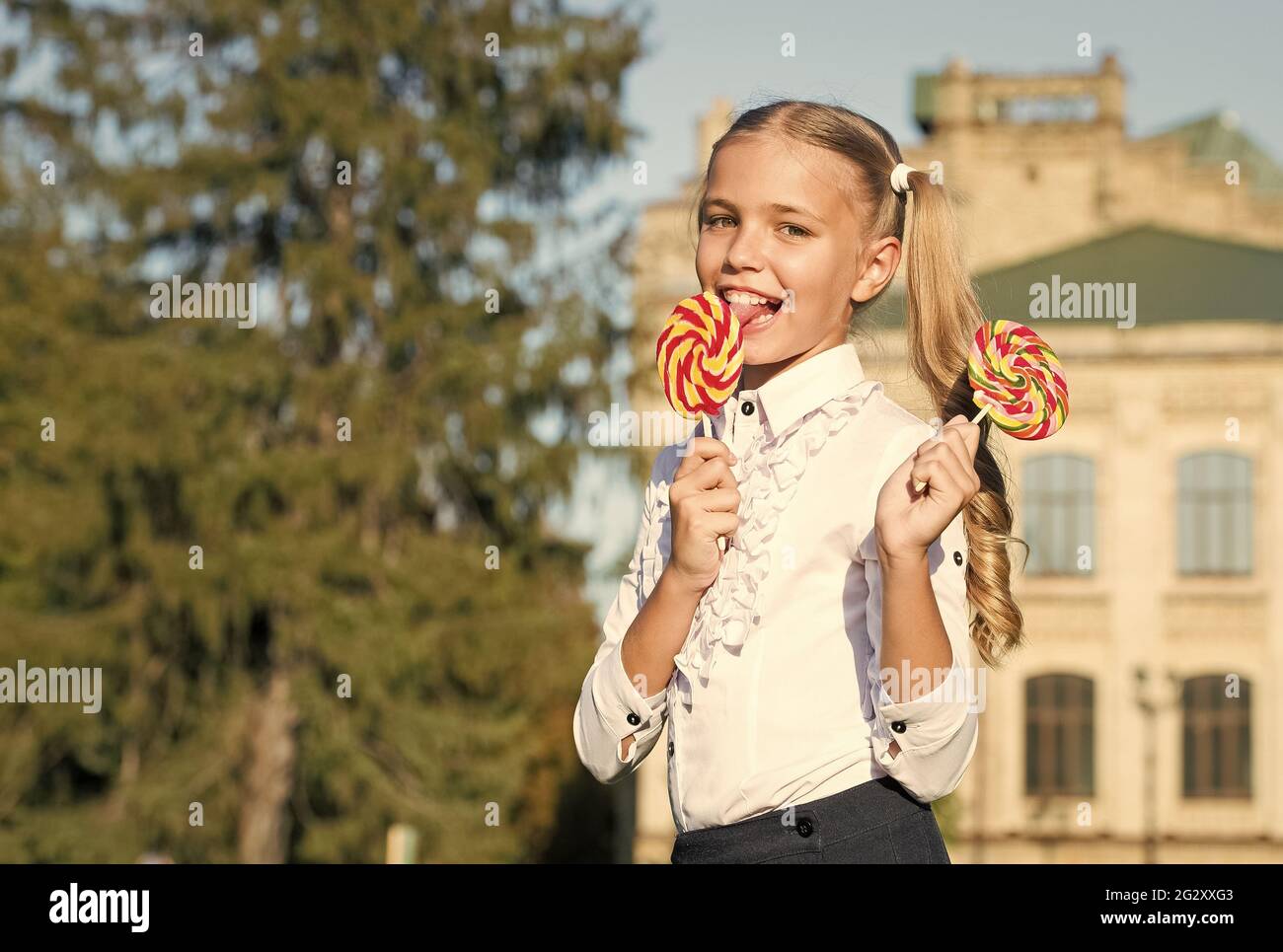 Happy student girl eat colorful lollipop outdoors, sweet motivation ...
