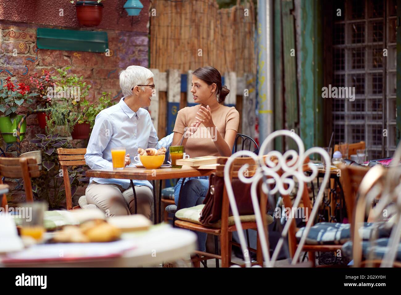 senior caucasian woman looking young adult female with smile who is ...