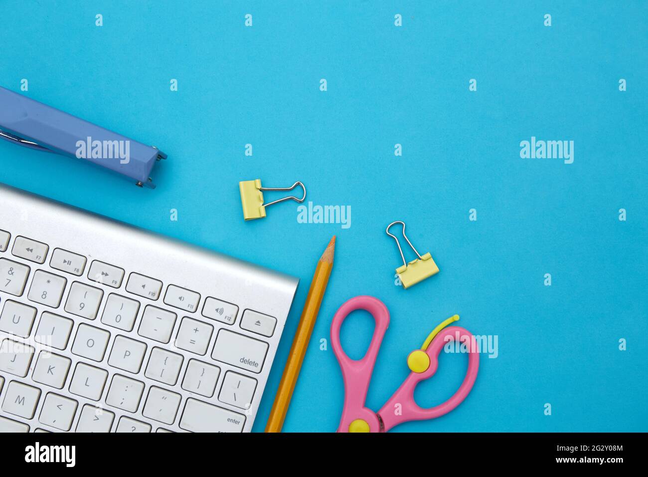 A paper stapler, paper clips, scissors, colored pencil and a keyboard ...
