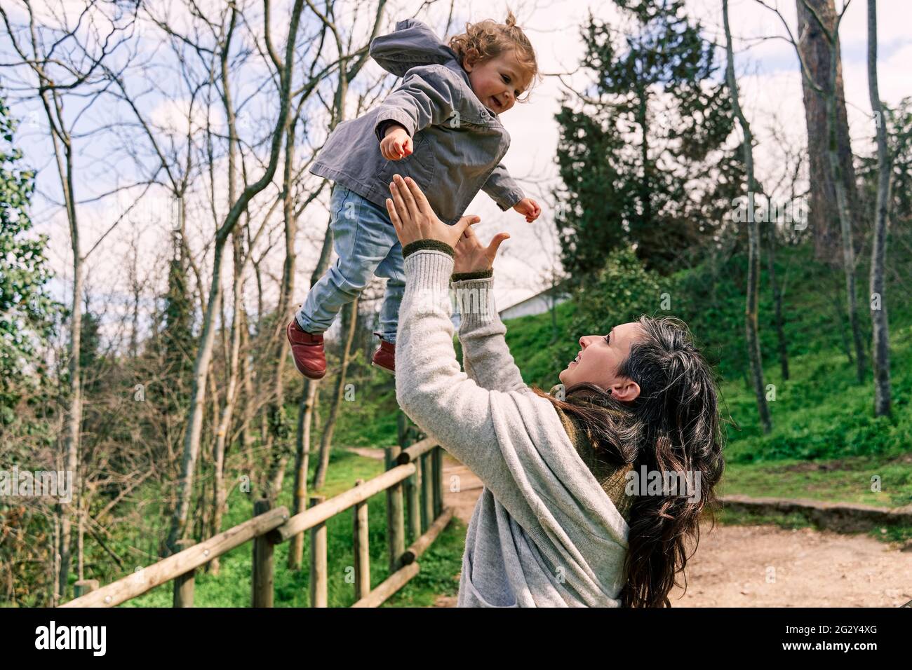Mother lifting her baby overhead in a playground Stock Photo - Alamy