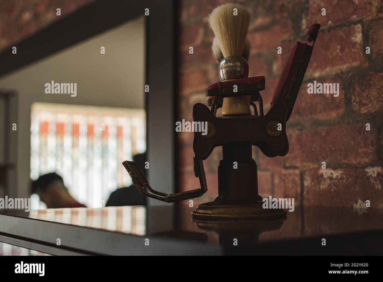 Shaving brush on a mini hairdressing chair in a vintage barber shop ...