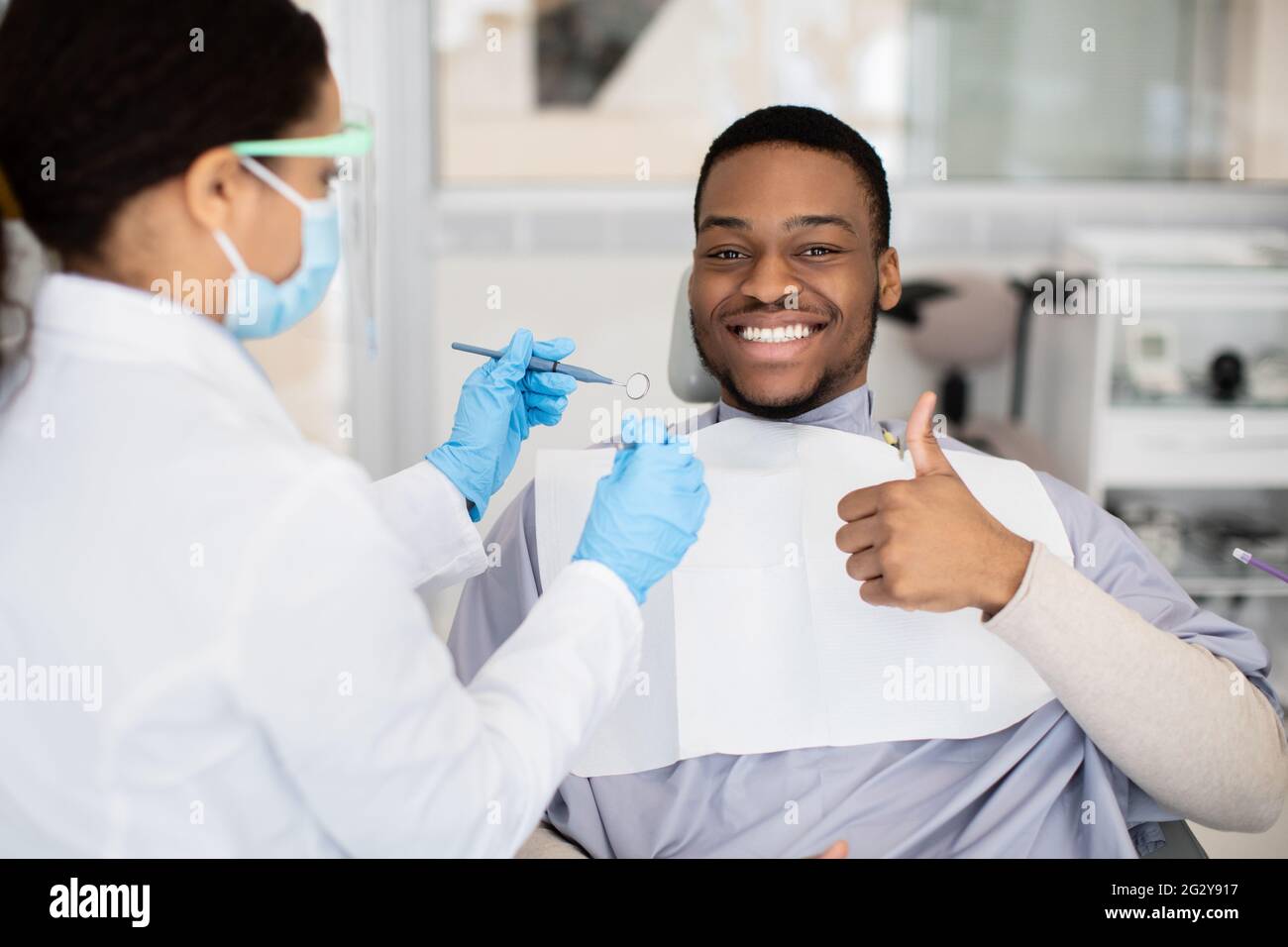 Black Male Patient Showing Thumb Up While Having Check Up With Dentist ...