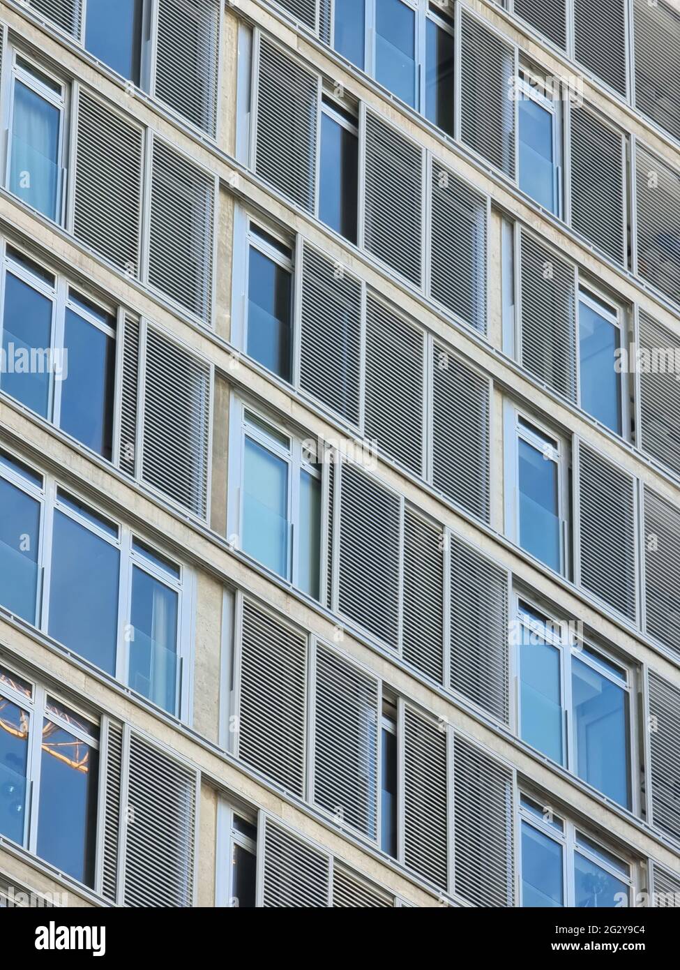 A vertical background of residential building windows with shutters ...