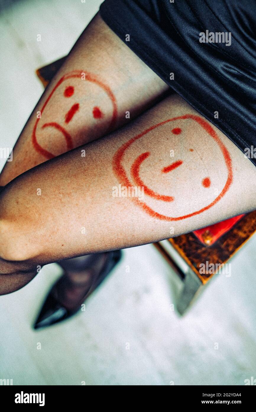 Emoji faces draw on woman legs with red lipstick Stock Photo - Alamy