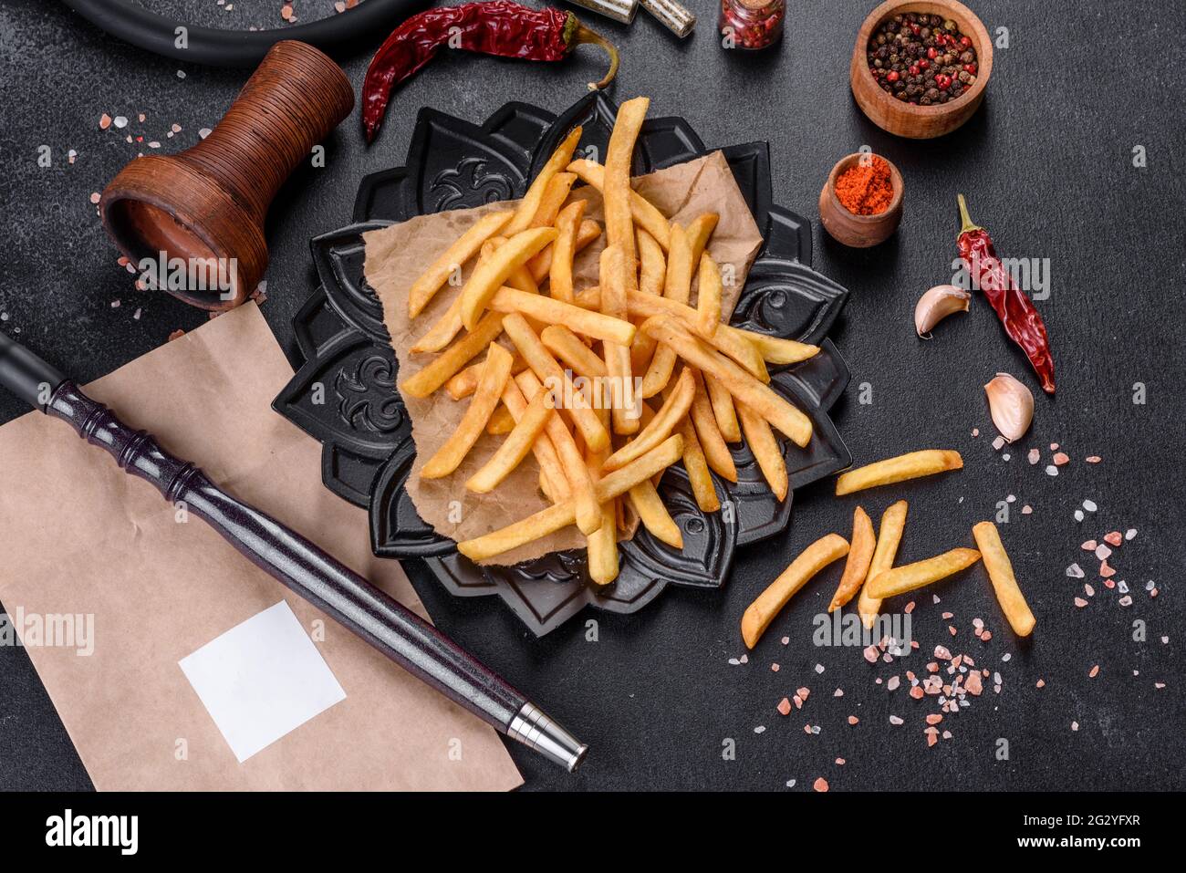 Tasty fried french fries with salt and spices on a dark background ...