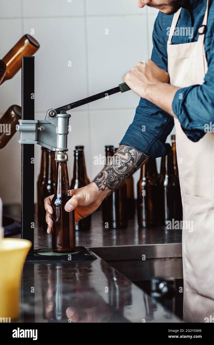 Young man work at beer plant. Brewer with industrial equipment at ...