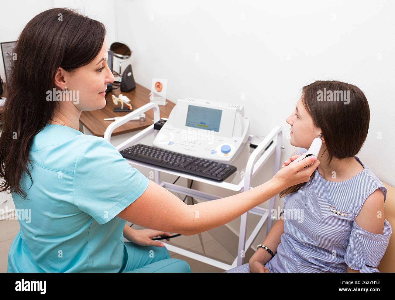 Audiologist doing a hearing exam on a girl. Impedance audiometry ...