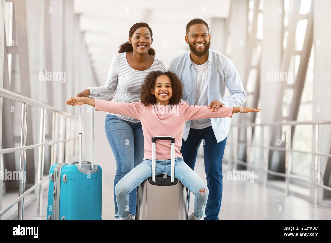 Happy black parents traveling with daughter, standing in airport Stock ...