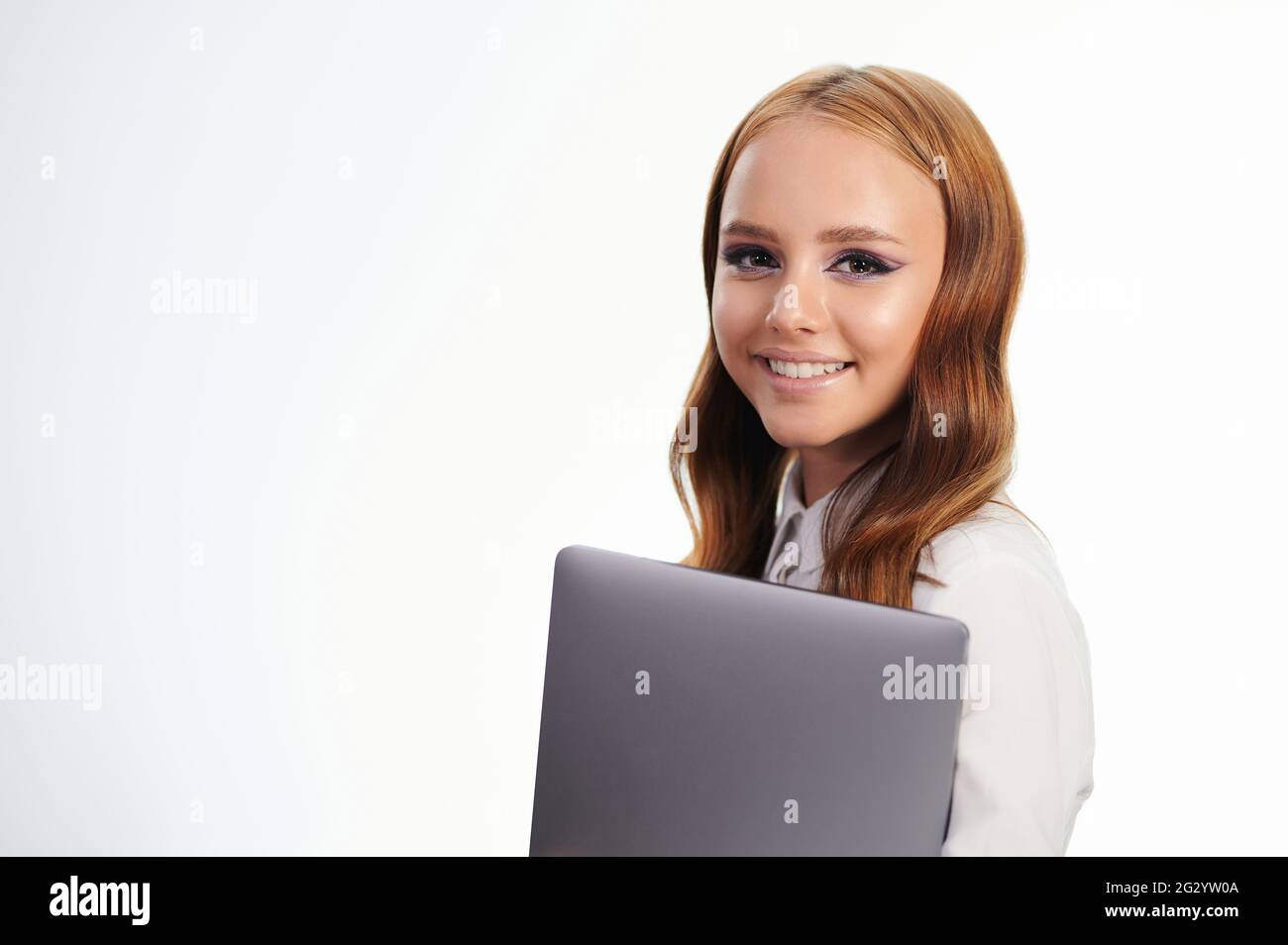 Portrait of happy studen girl with laptop isolated on white studio ...
