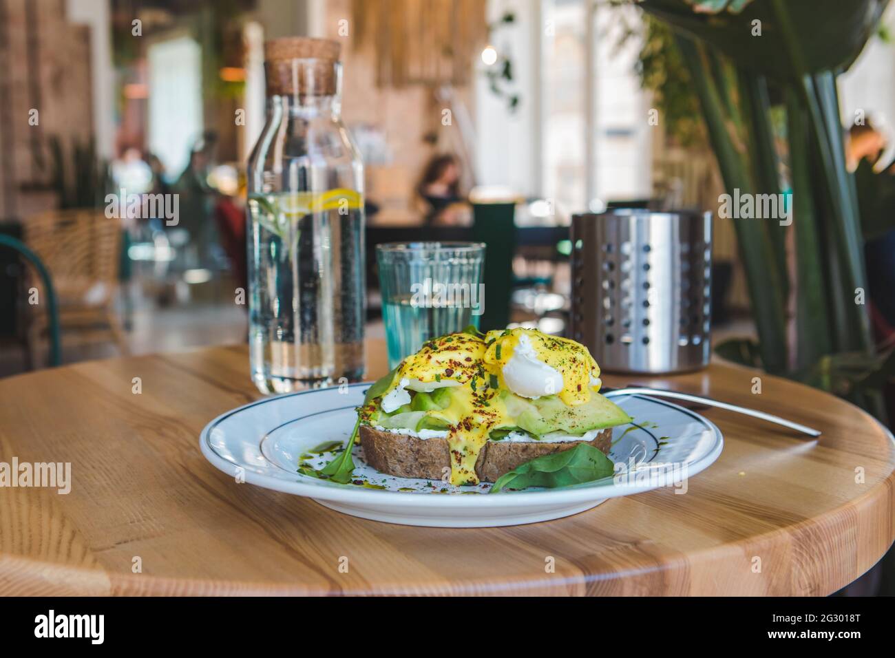 toast with avocado and eggs on the plate in restaurant brown colors ...