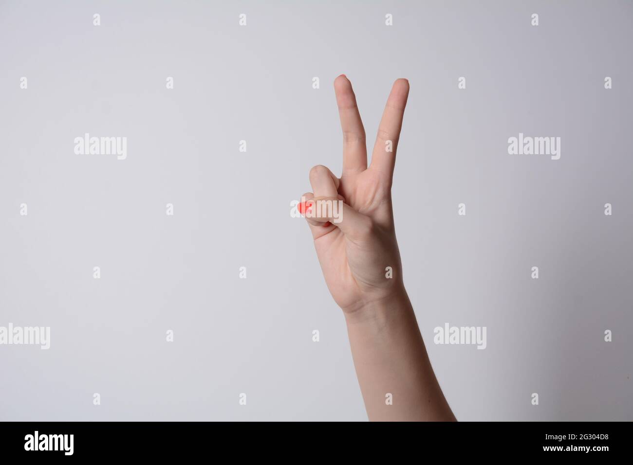 Woman raising two fingers up on hand it is shows peace strength fight ...