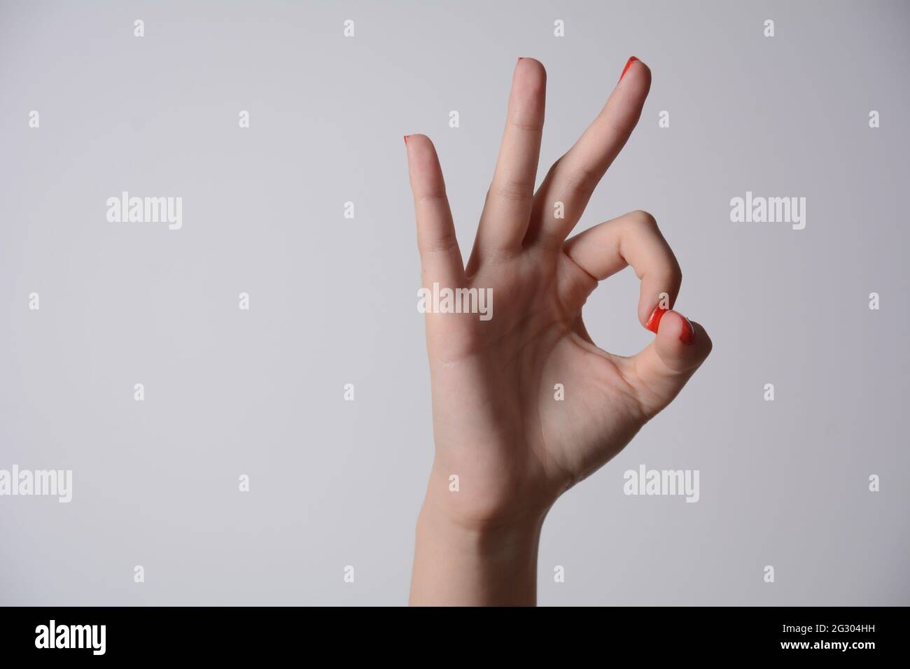 Woman's hand ok sign on white background Stock Photo - Alamy