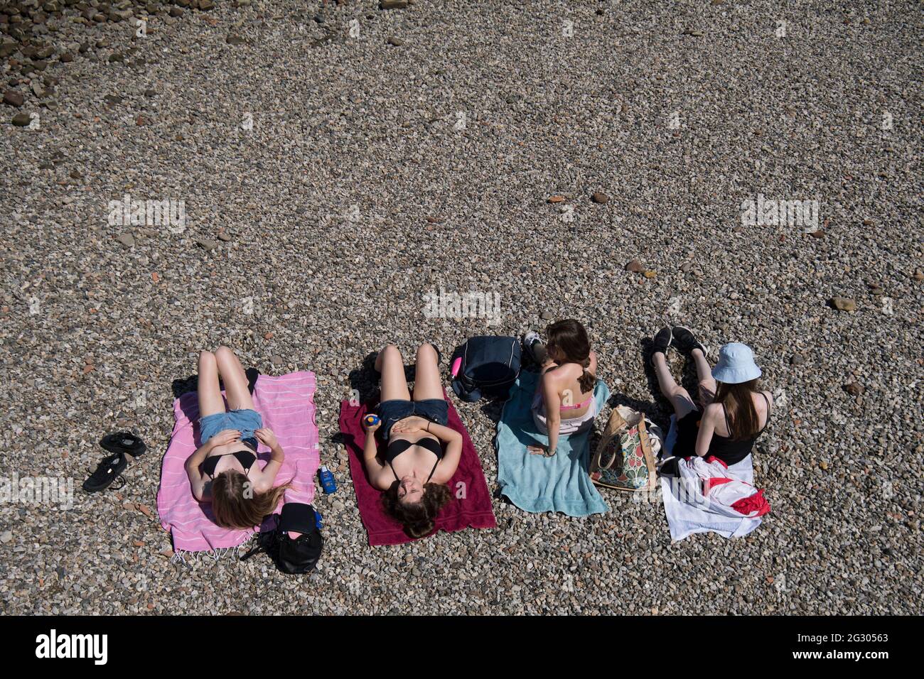 People sunbathe on the river bank near Millennium Bridge, in London ...