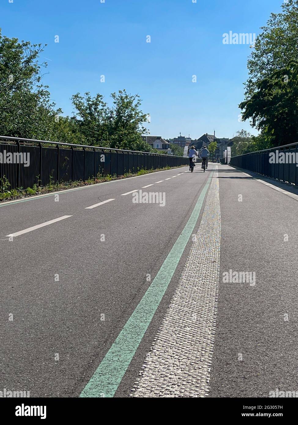 A sign on the side of a road. Bicycle path and a couple on bicycles ...