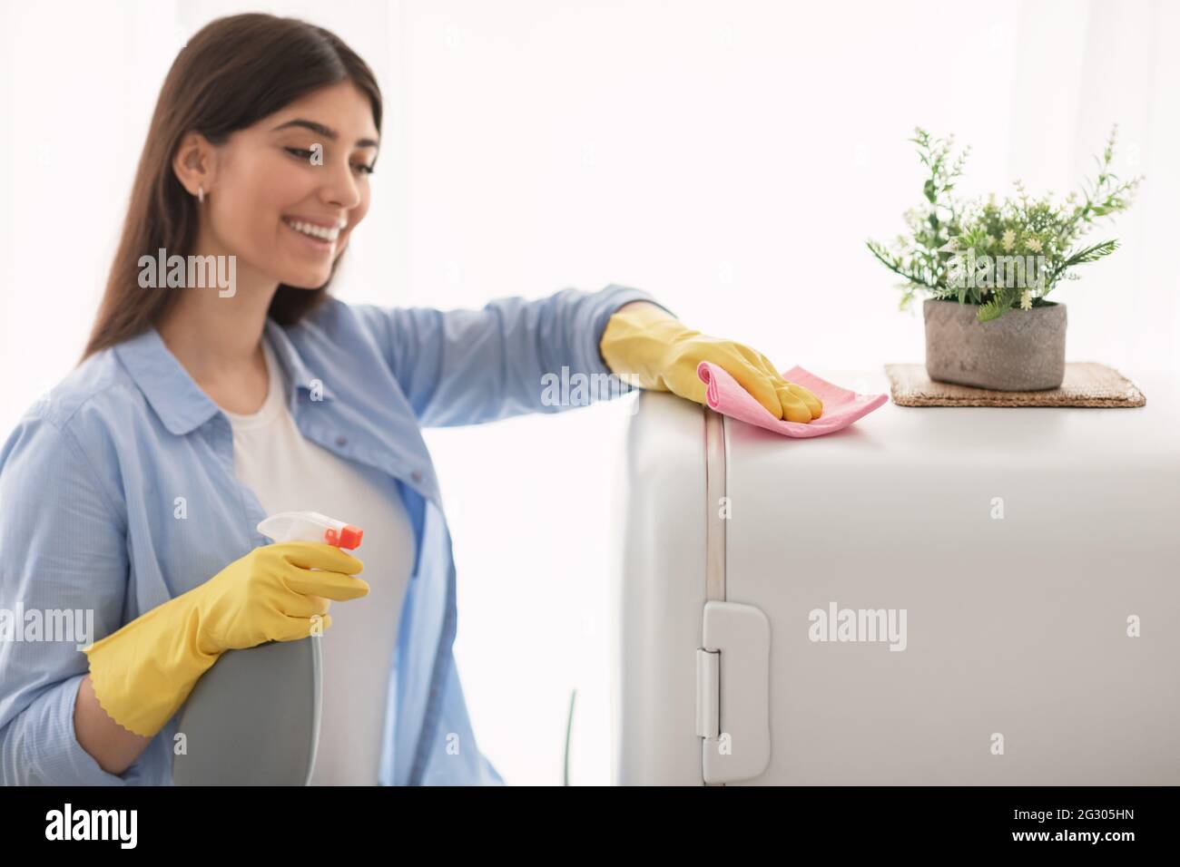 Cheerful young housewife cleaning dining table at kitchen Stock Photo ...