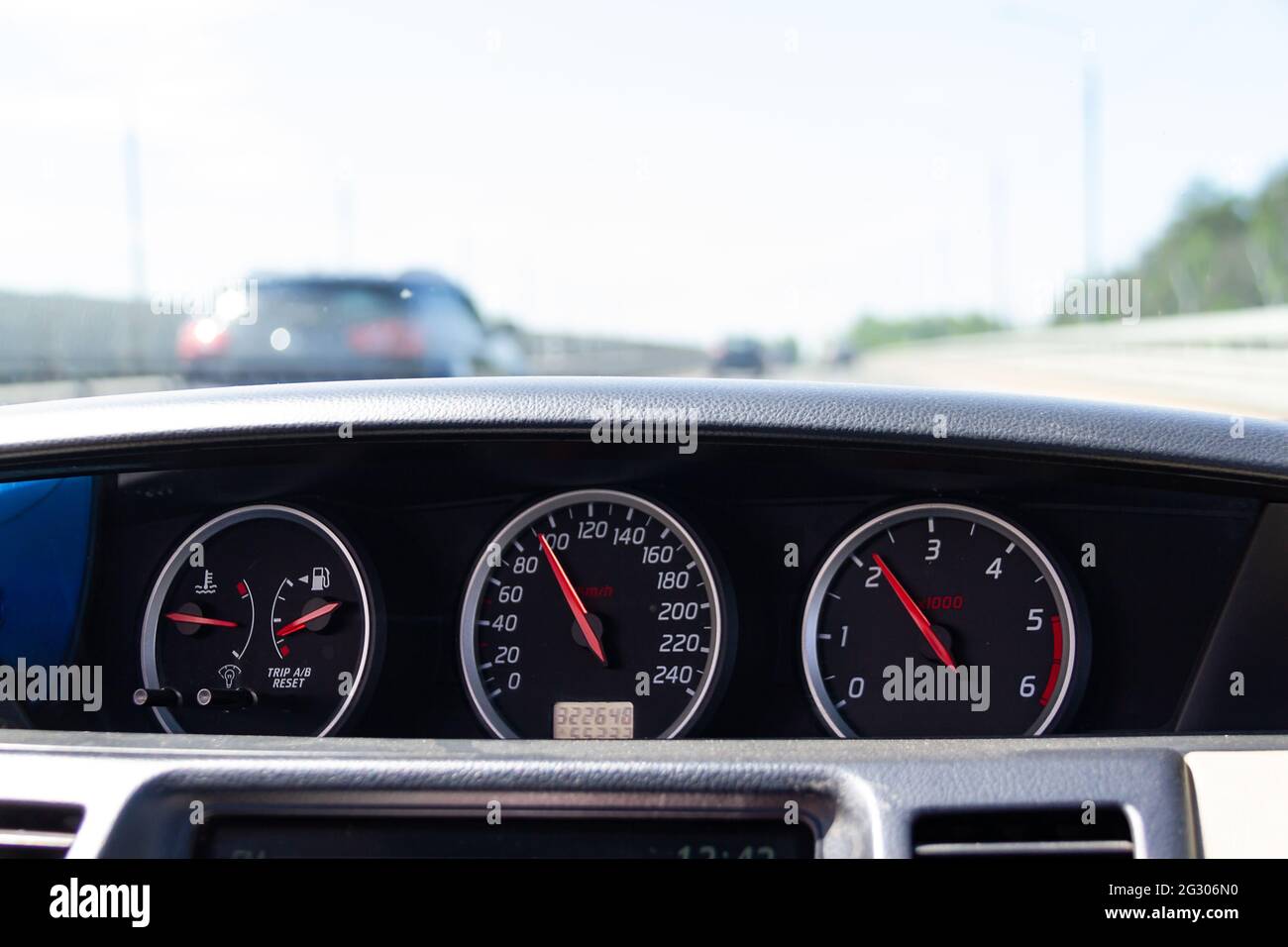 Close-up of a car dashboard. Blurred view of the road with moving cars ...