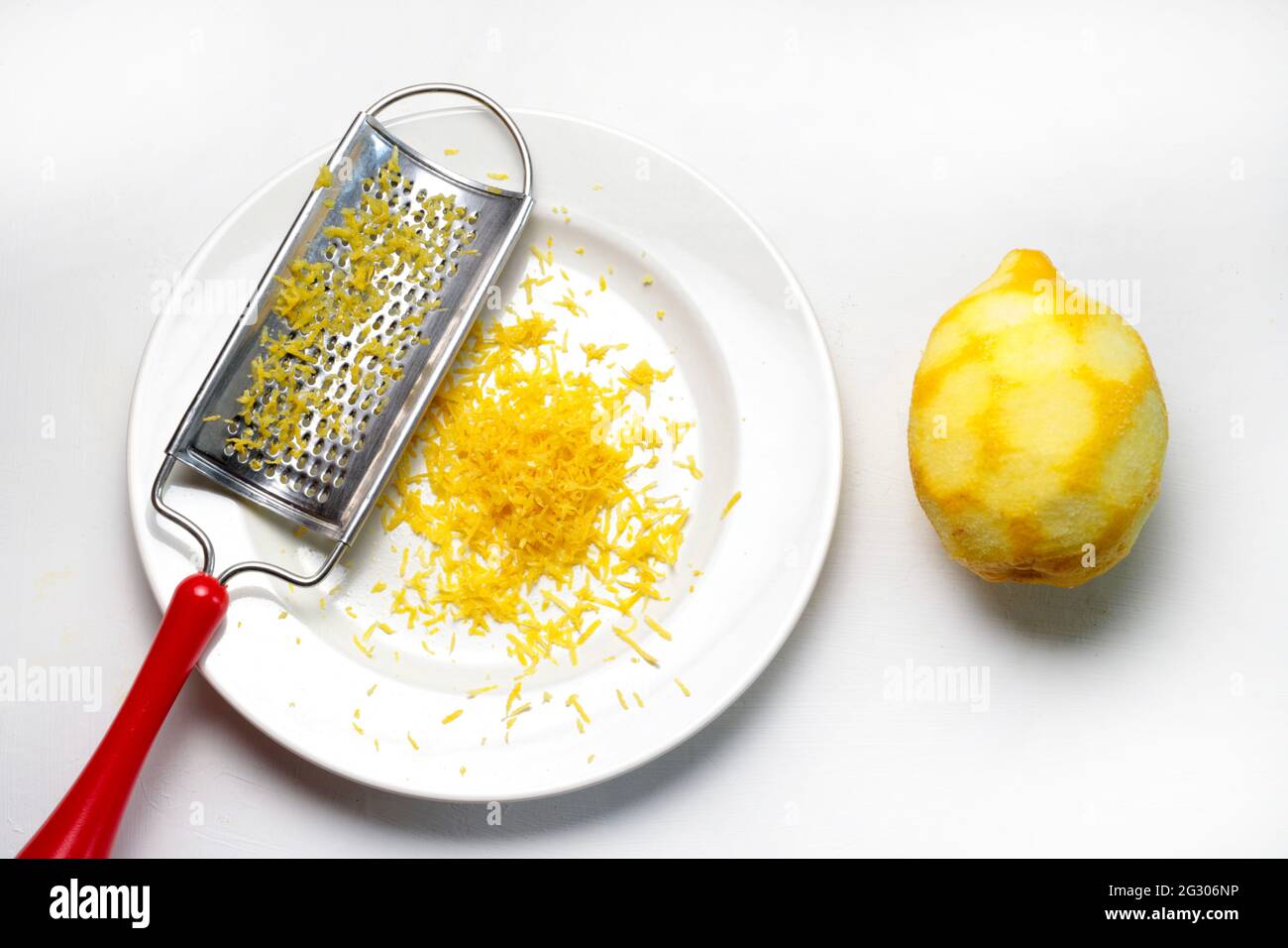 Grater and lemon zest isolated on white background. Directly above ...