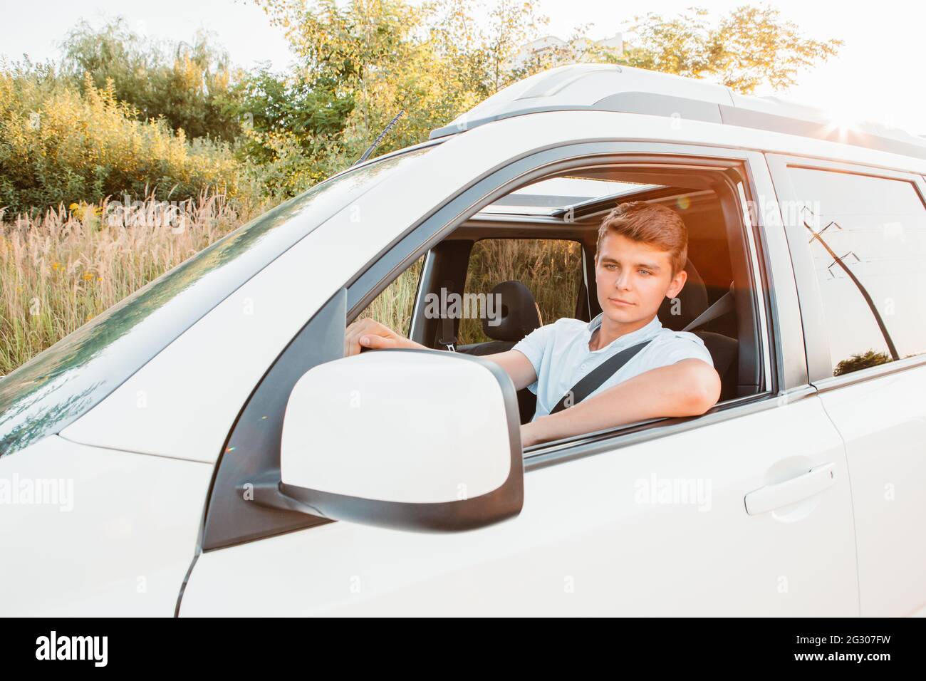 young handsome confident man driving car. road trip Stock Photo - Alamy