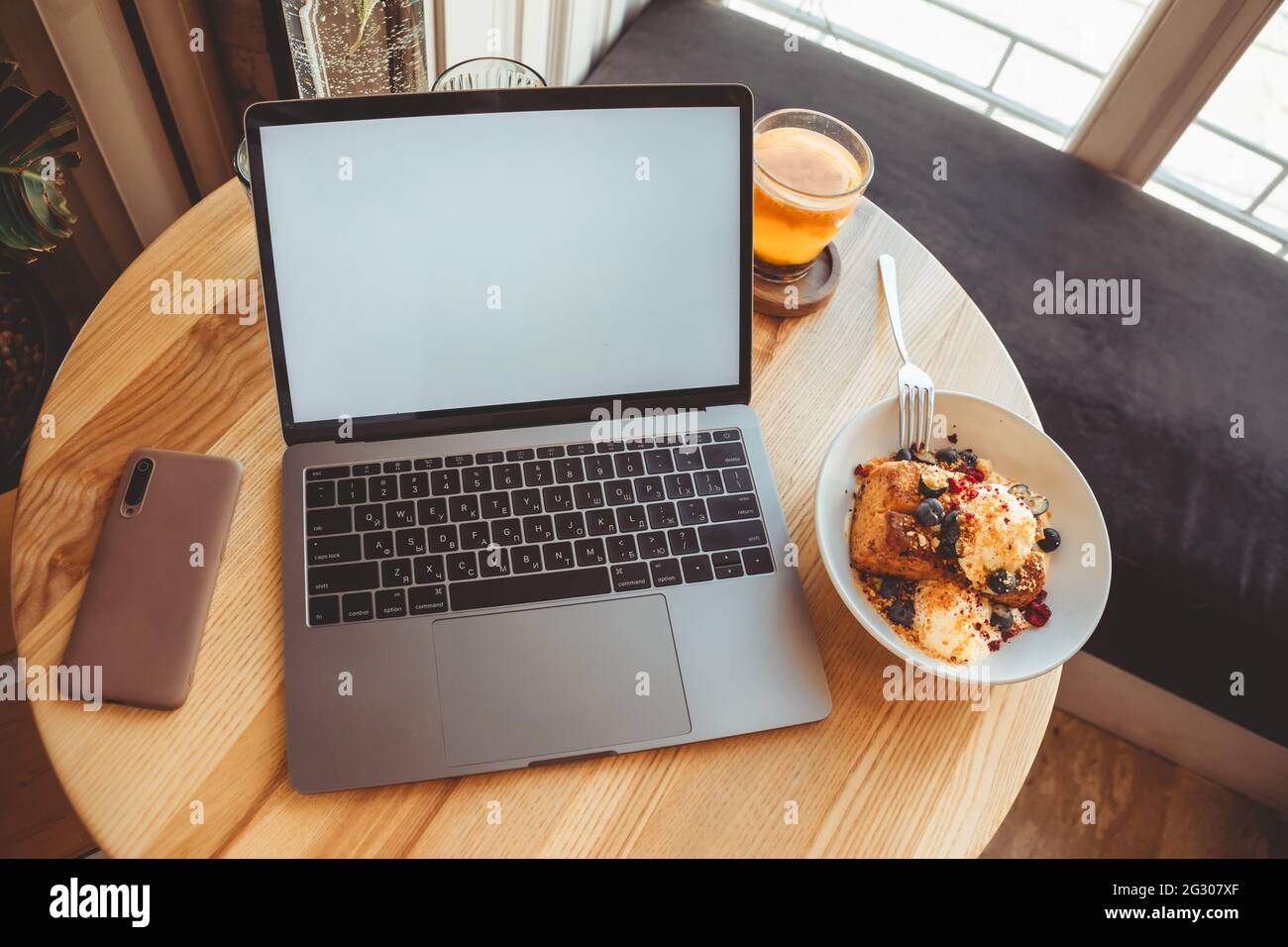 the laptop in cafe on the table with white screen in cafe copy space ...