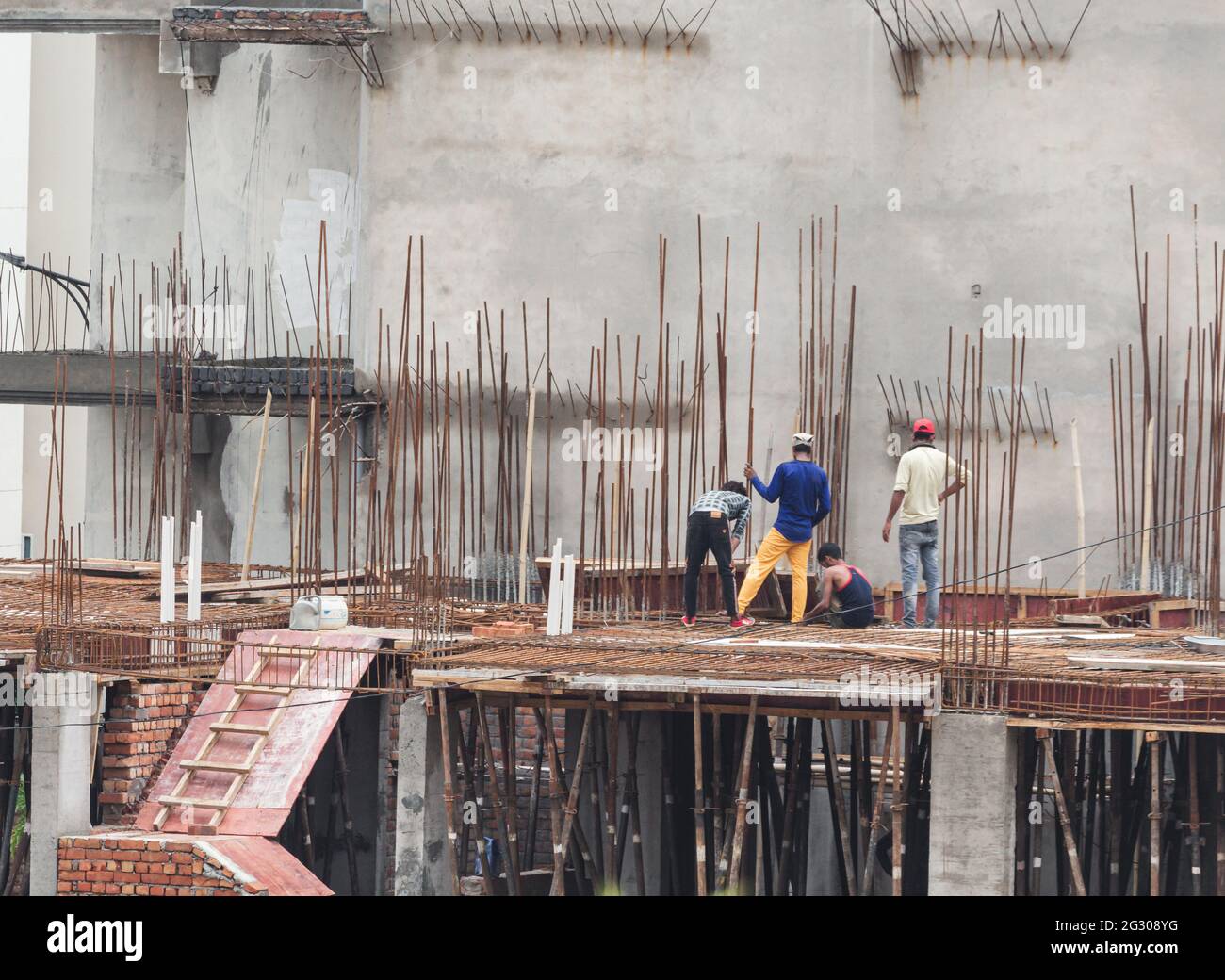 Four construction workers working on the roof supported by bars Stock ...