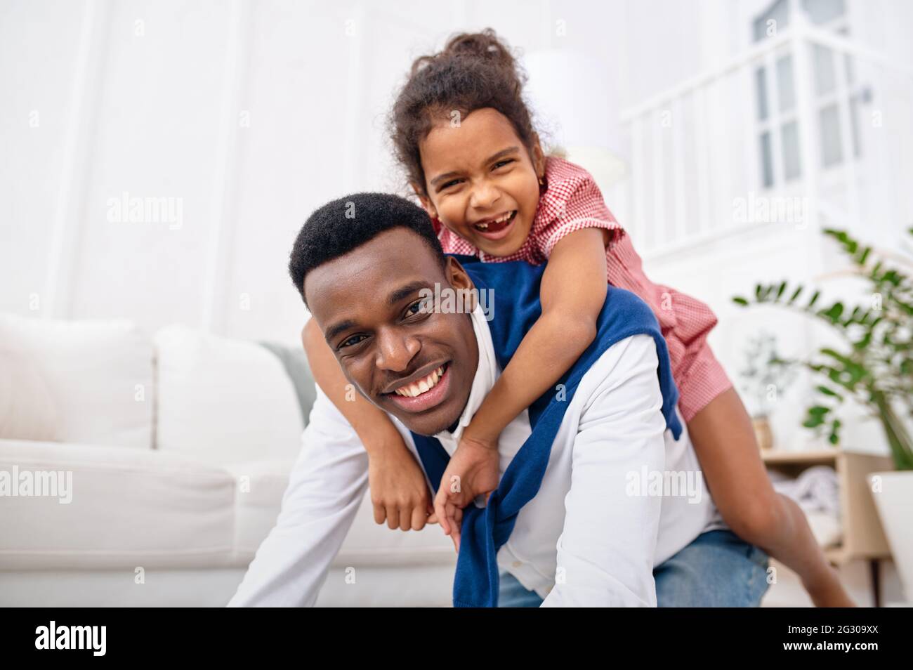 Smiling father and little daughter in living room Stock Photo - Alamy