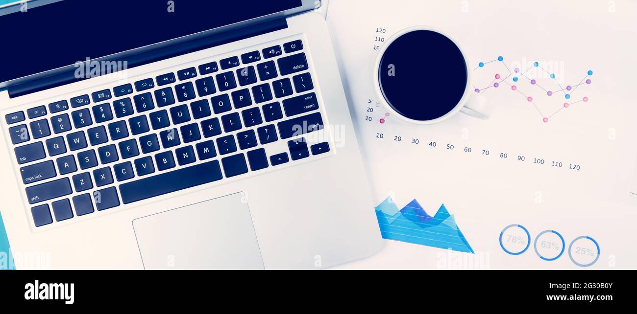 Laptop computer and documents report statistic financial with graph and ...