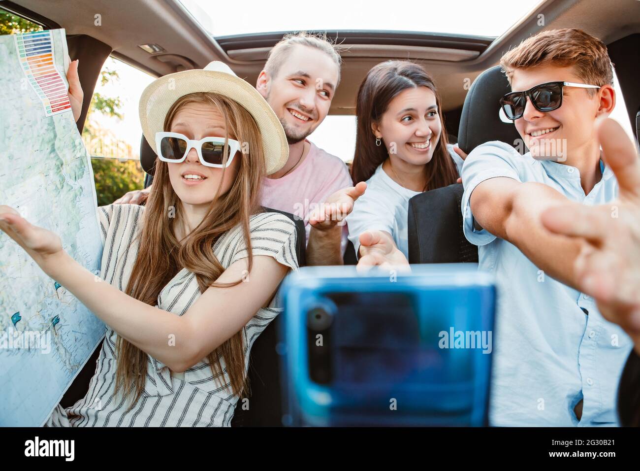 four friends in car navigation on phone. road trip Stock Photo - Alamy