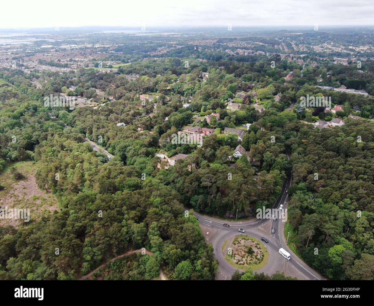 aerial view of a road roundabout set in a wooded and heathland area in ...