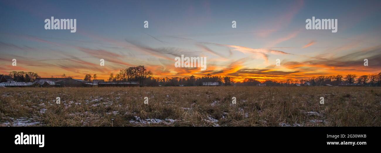 Panorama of beautiful sunset on a winter evening with field covered in ...
