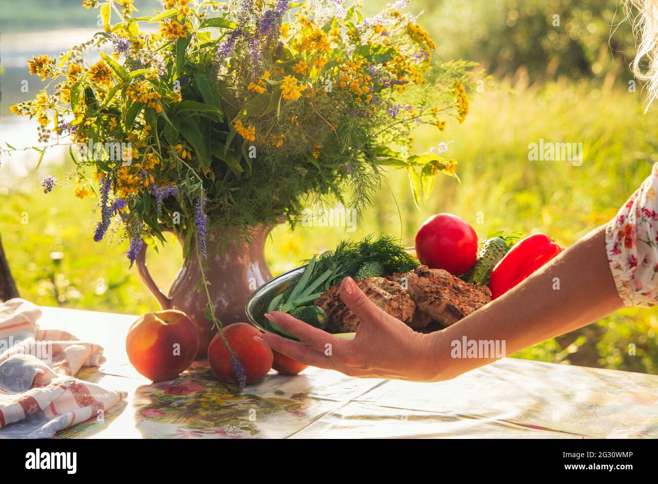 Still life outdoor with barbecue and bouquet wildflowers Stock Photo ...