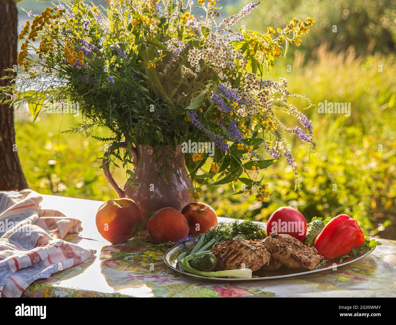 Still life outdoor with barbecue and bouquet wildflowers Stock Photo ...
