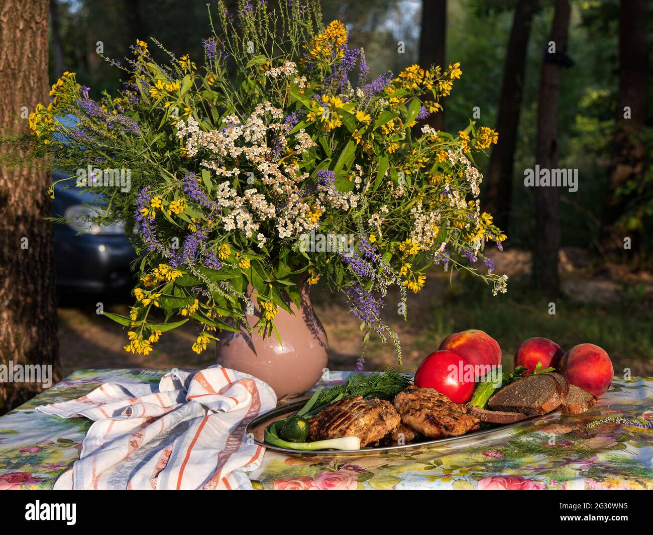 Still life outdoor with barbecue and bouquet wildflowers Stock Photo ...