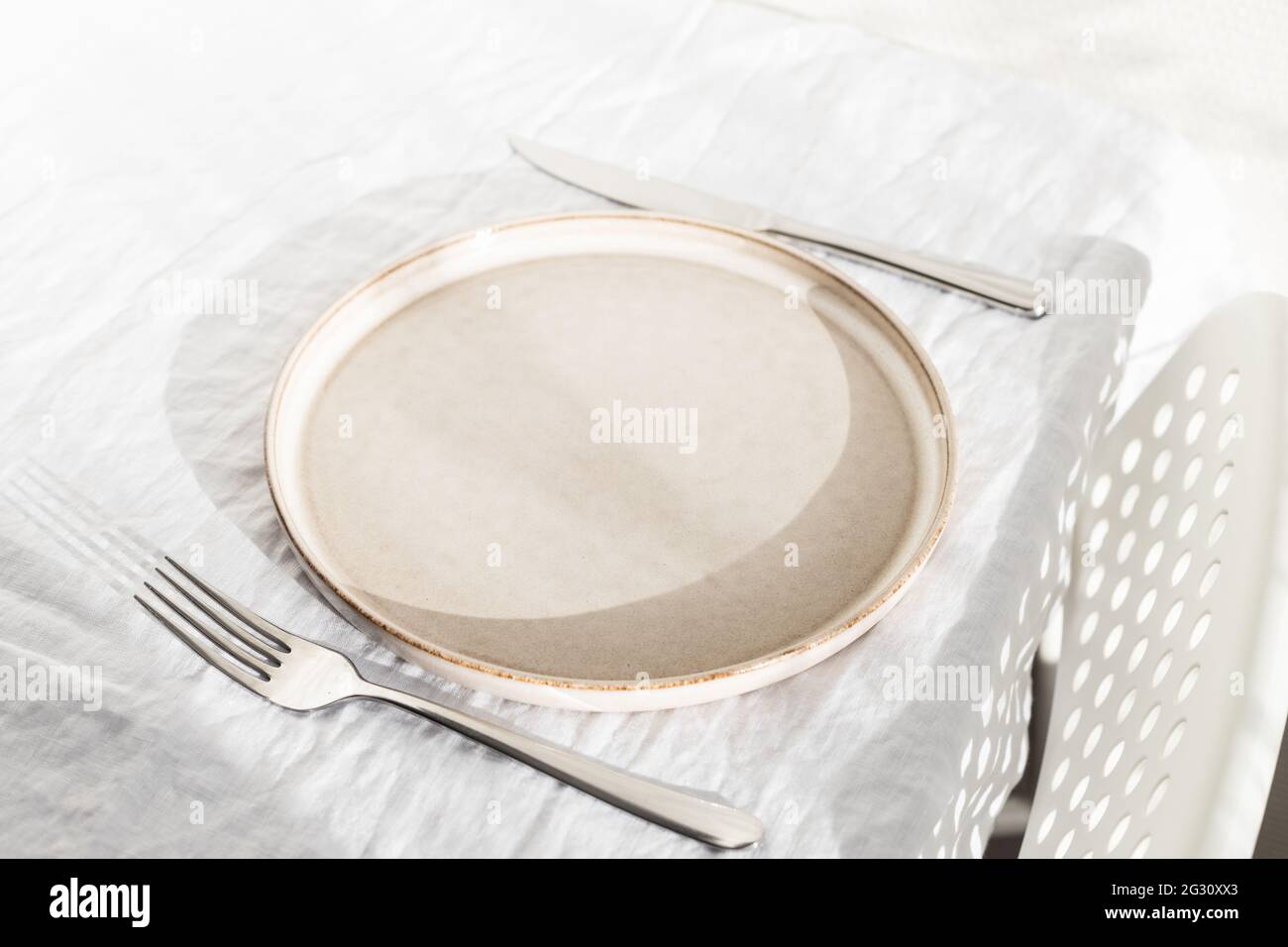 Empty plate on white linen tablecloth Stock Photo - Alamy