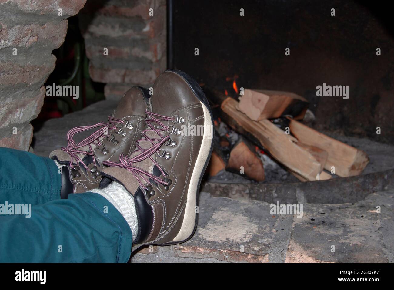 Warming feet by the fireplace in a log cabin Stock Photo - Alamy