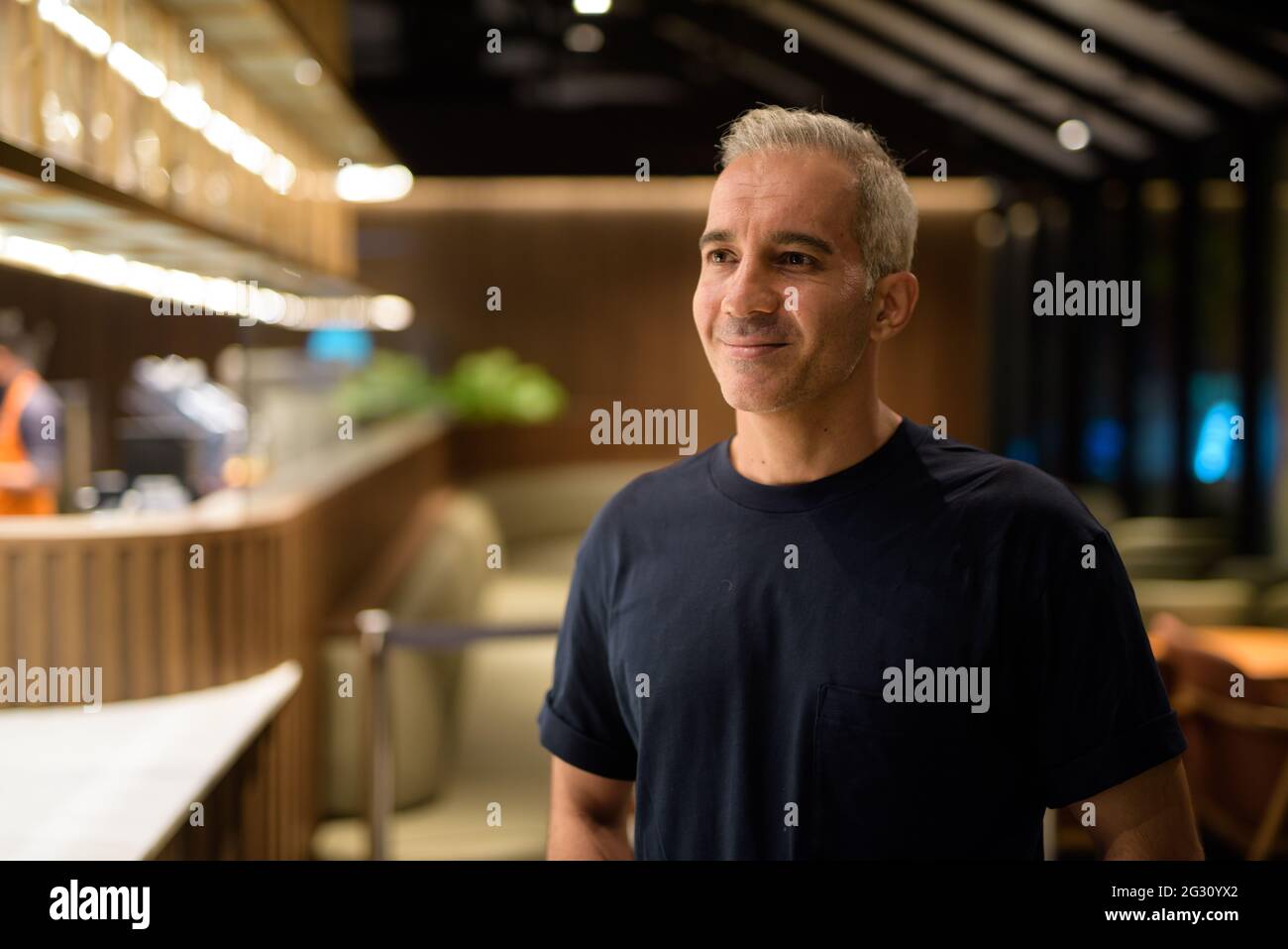 Portrait of man inside coffee shop at night thinking Stock Photo - Alamy