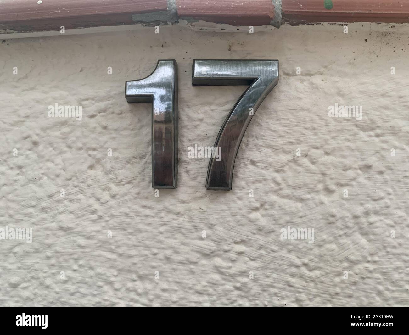 A closeup shot of number "17" in the address on the building wall Stock ...