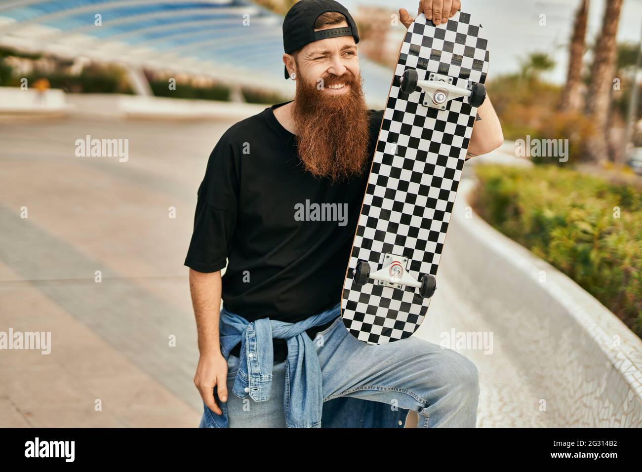 Young irish skater man smiling happy holding skate at the city Stock ...