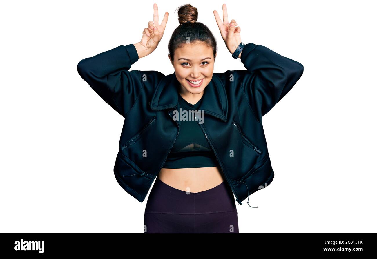 Young hispanic girl wearing sportswear posing funny and crazy with ...