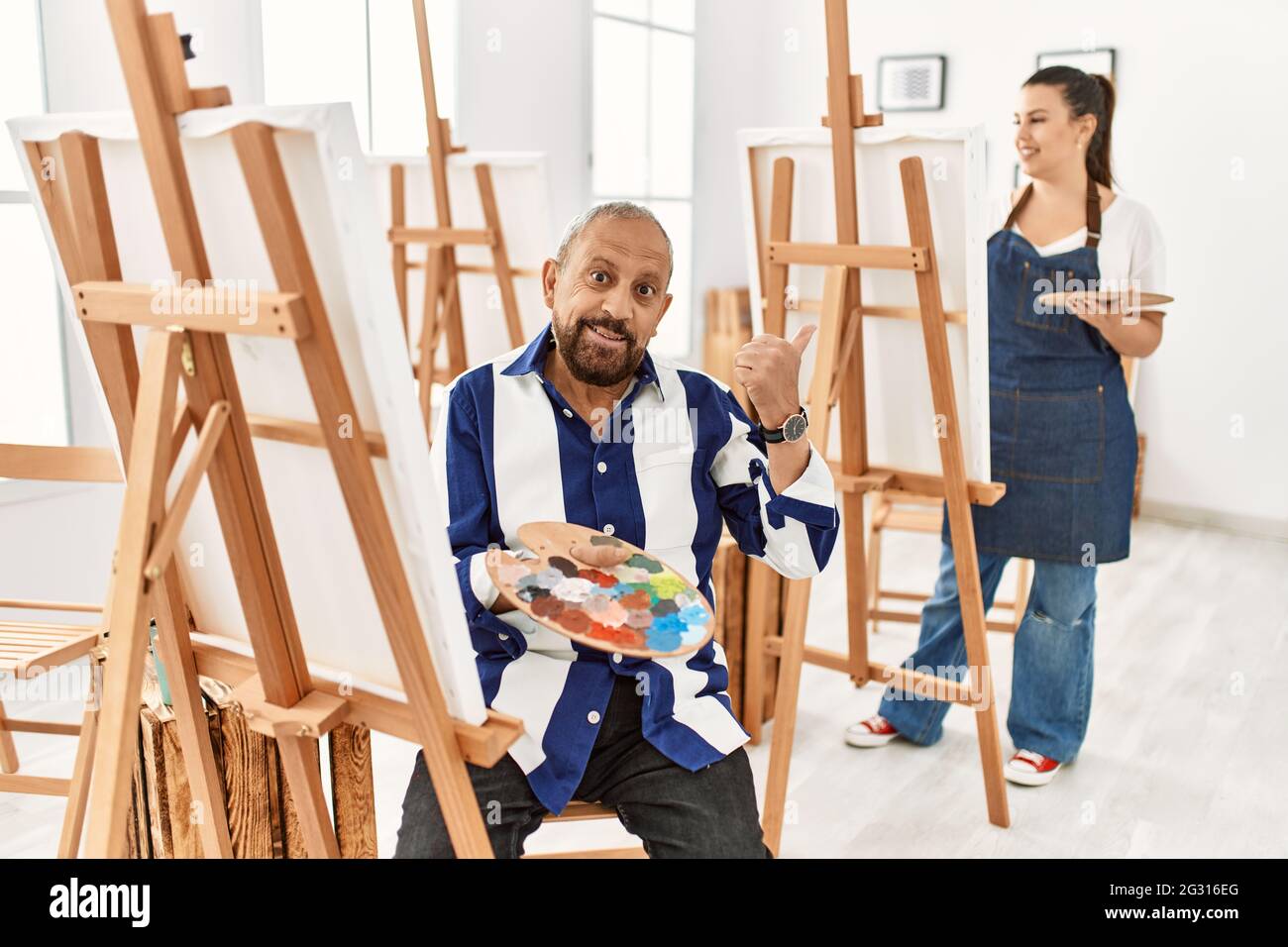 Senior artist man at art studio smiling with happy face looking and ...