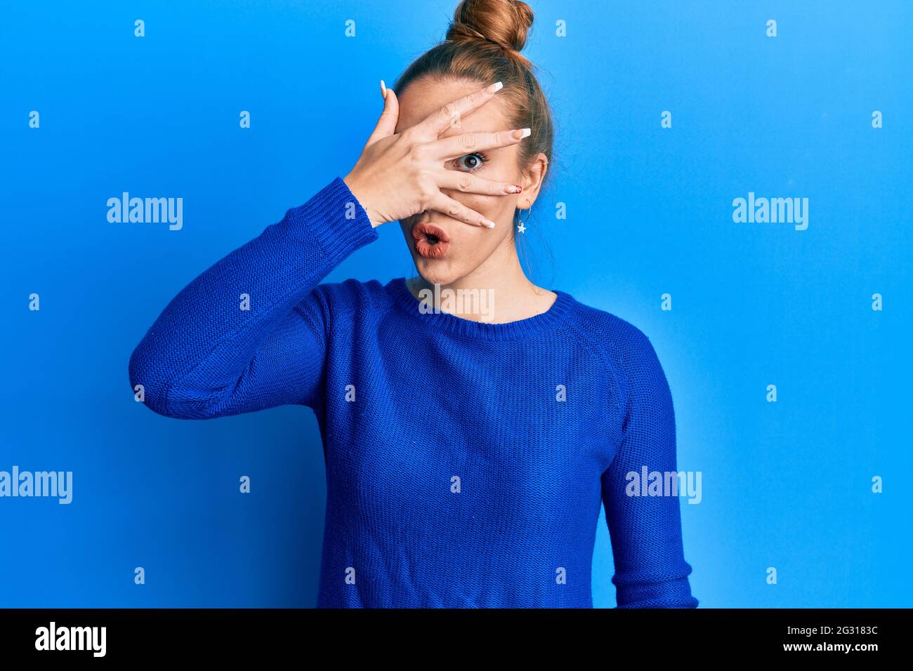 Young blonde woman wearing casual clothes peeking in shock covering ...