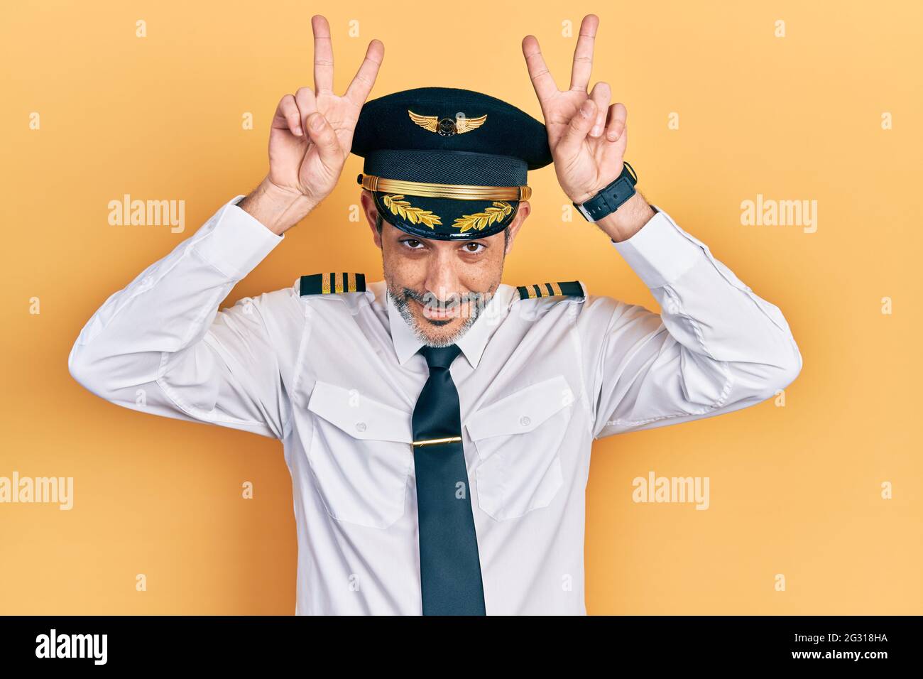 Handsome middle age man with grey hair wearing airplane pilot uniform ...