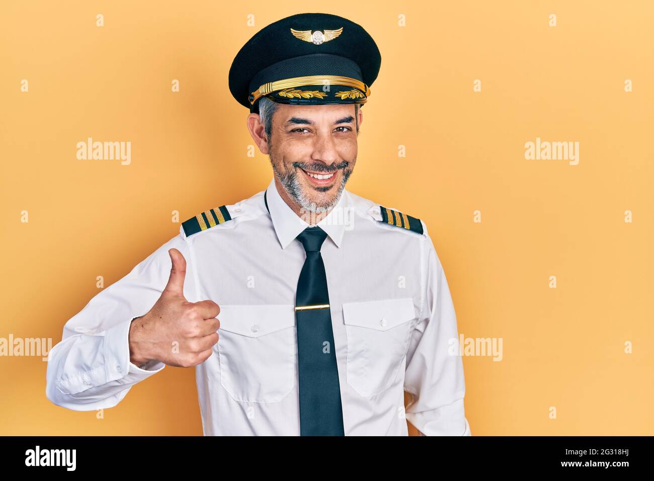 Handsome middle age man with grey hair wearing airplane pilot uniform ...