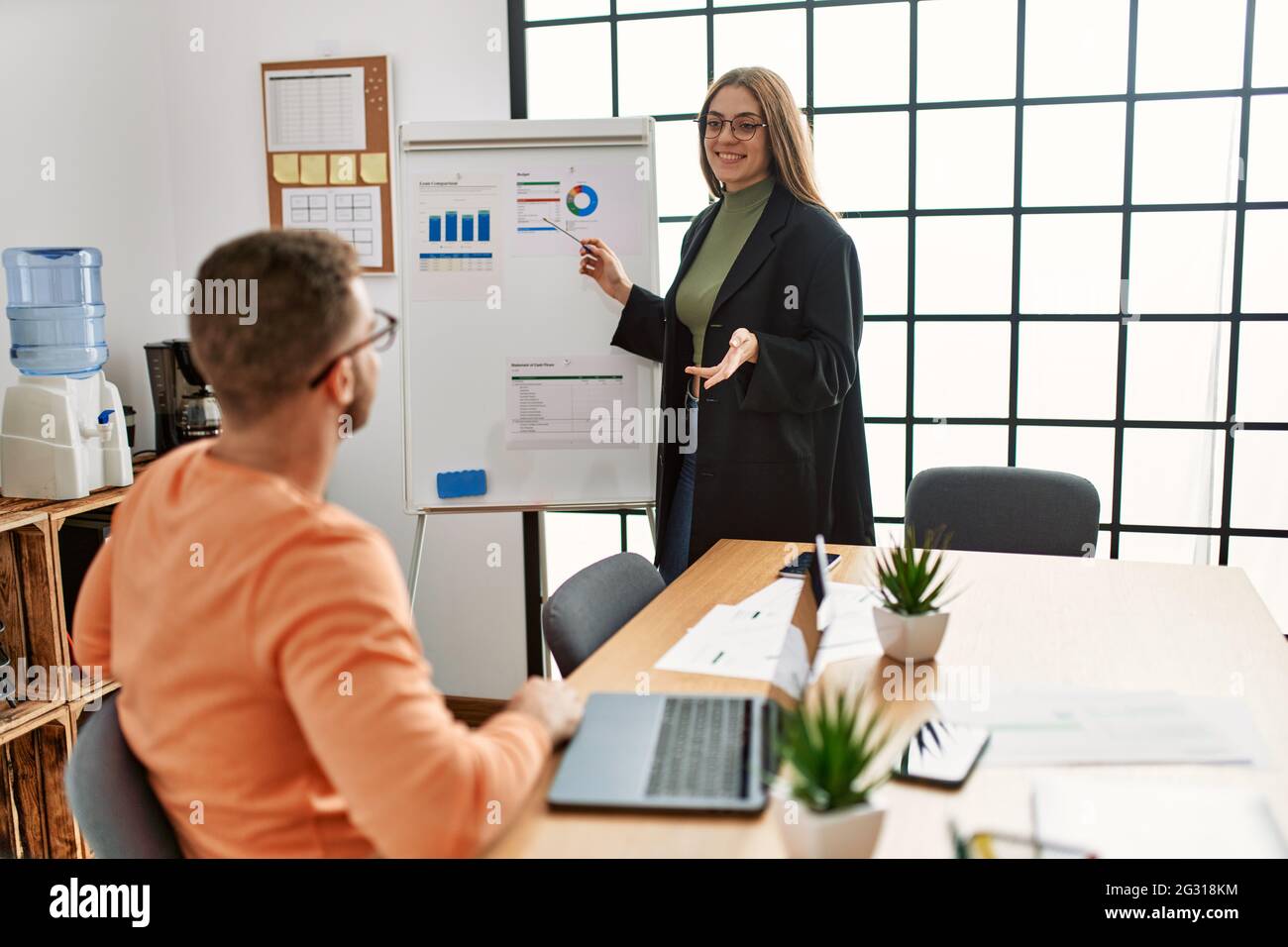 Two caucasian business executives on chart presentation at the office ...