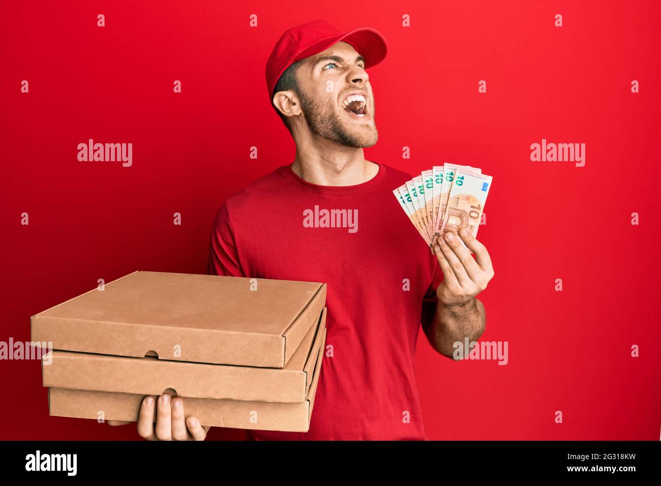 Young caucasian man holding take away food and 10 euros banknotes angry ...