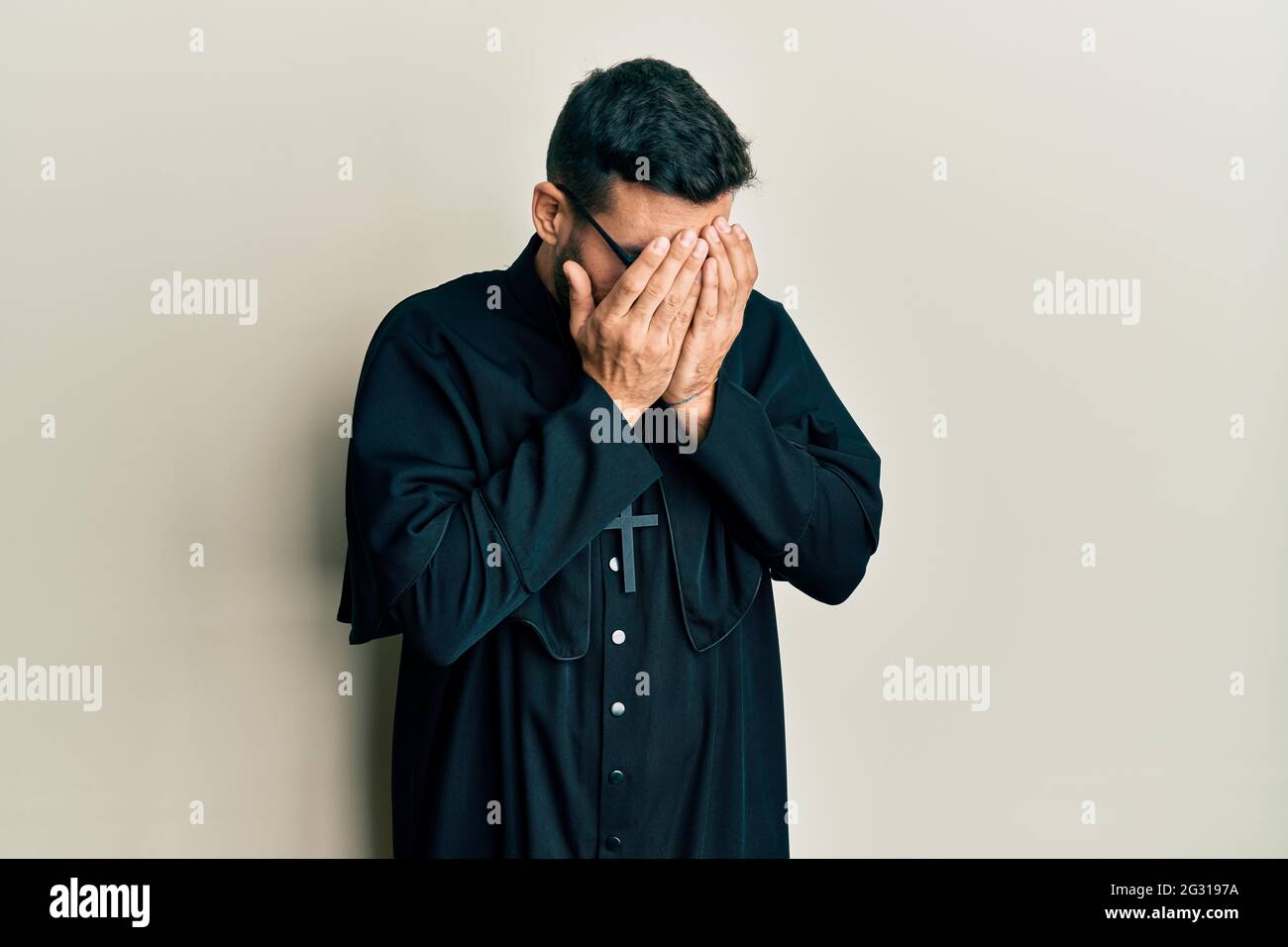 Young hispanic man wearing priest uniform standing over white ...