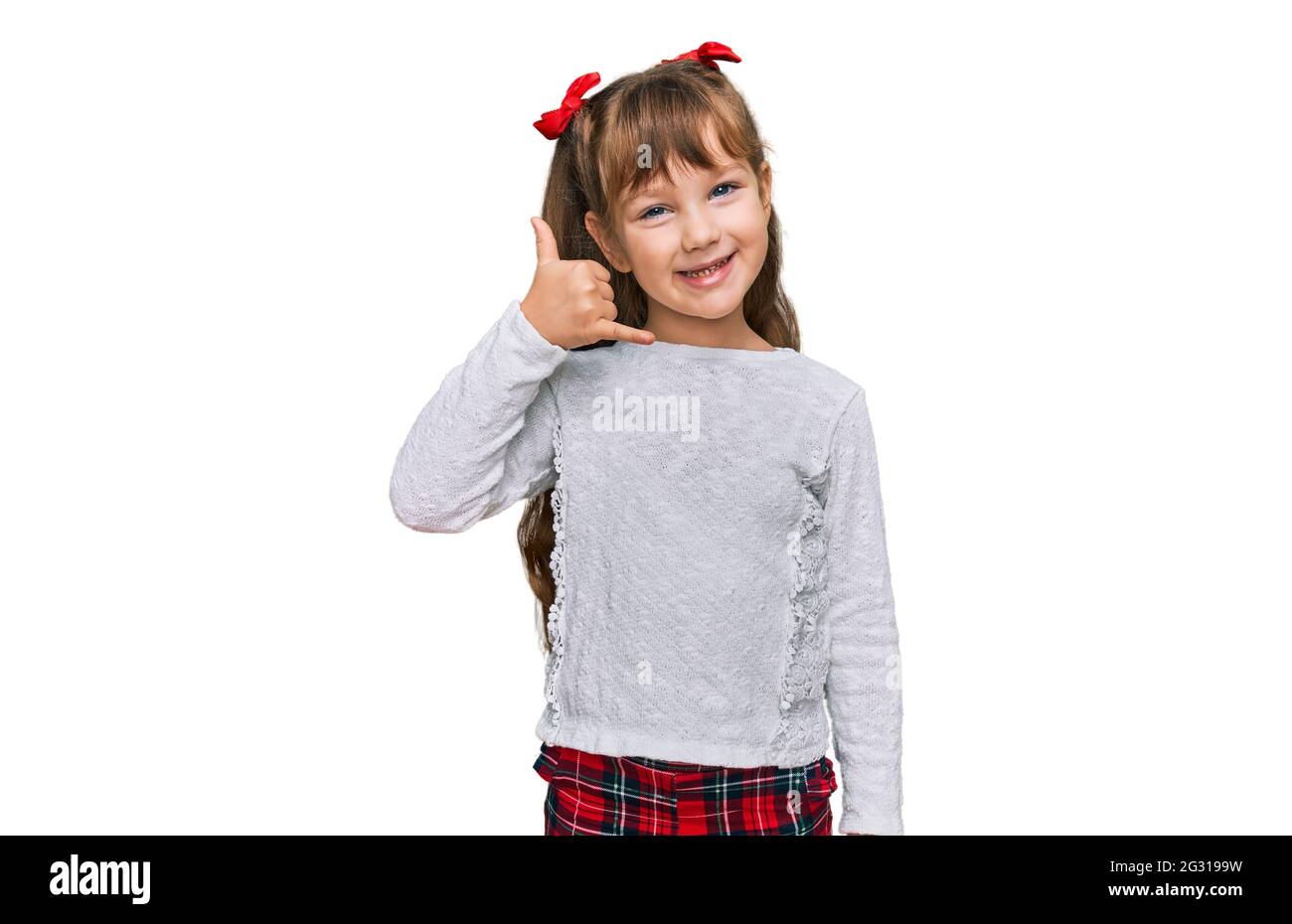 Little caucasian girl kid wearing casual clothes smiling doing phone ...
