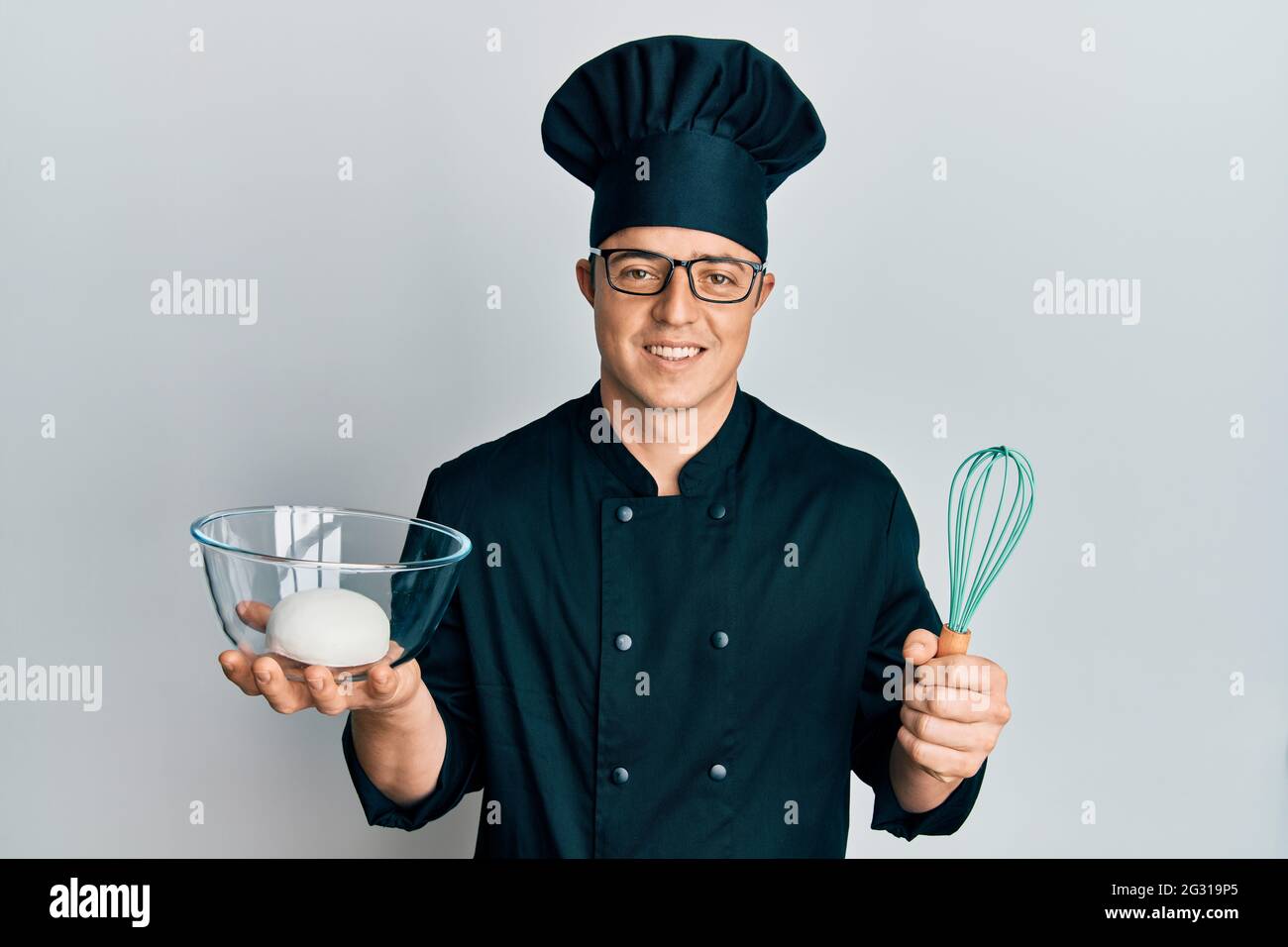 Handsome young man holding bread dough and blender smiling with a happy ...