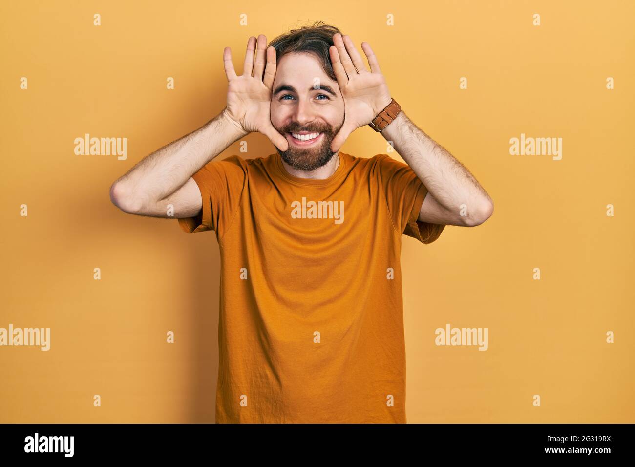 Caucasian man with beard wearing casual yellow t shirt smiling cheerful ...