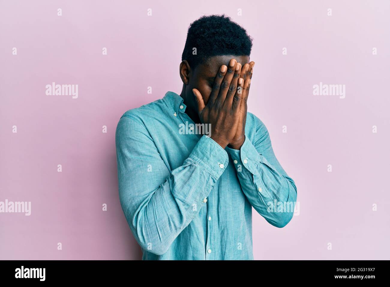 Handsome black man wearing casual clothes with sad expression covering ...