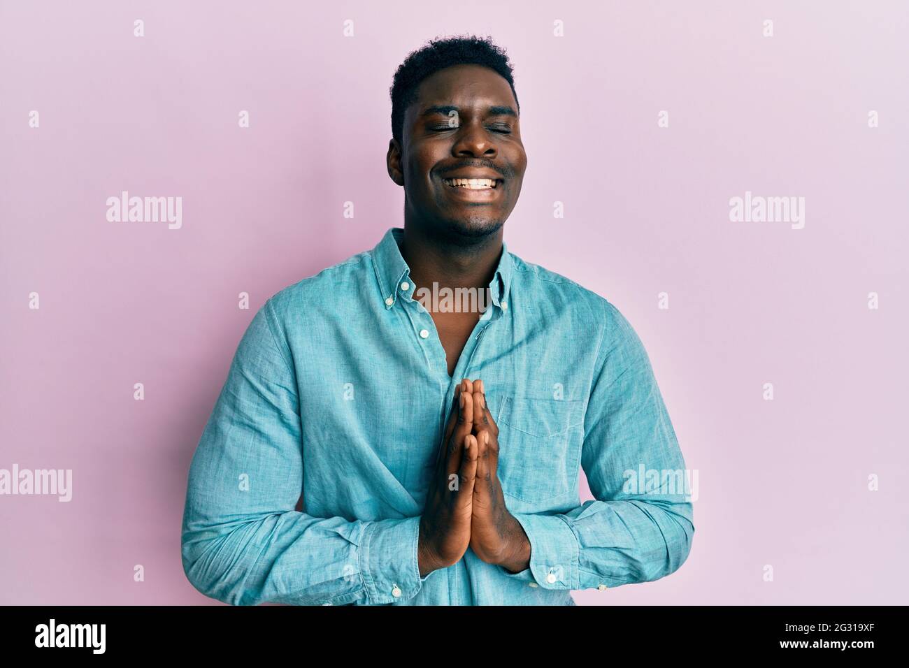Handsome black man wearing casual clothes begging and praying with ...